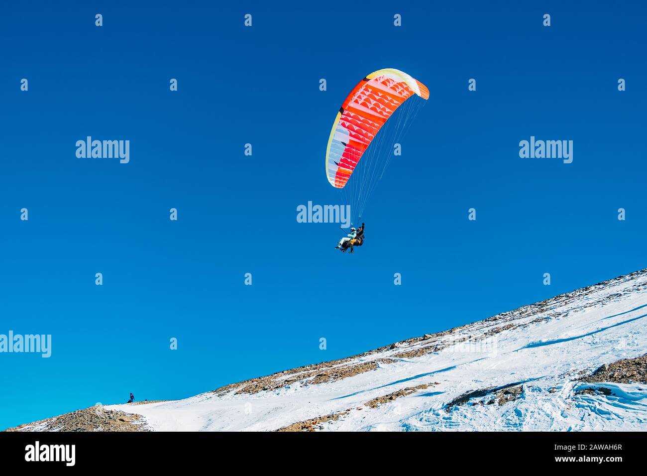 Flying on a paraglider above snowy mountains Stock Photo - Alamy