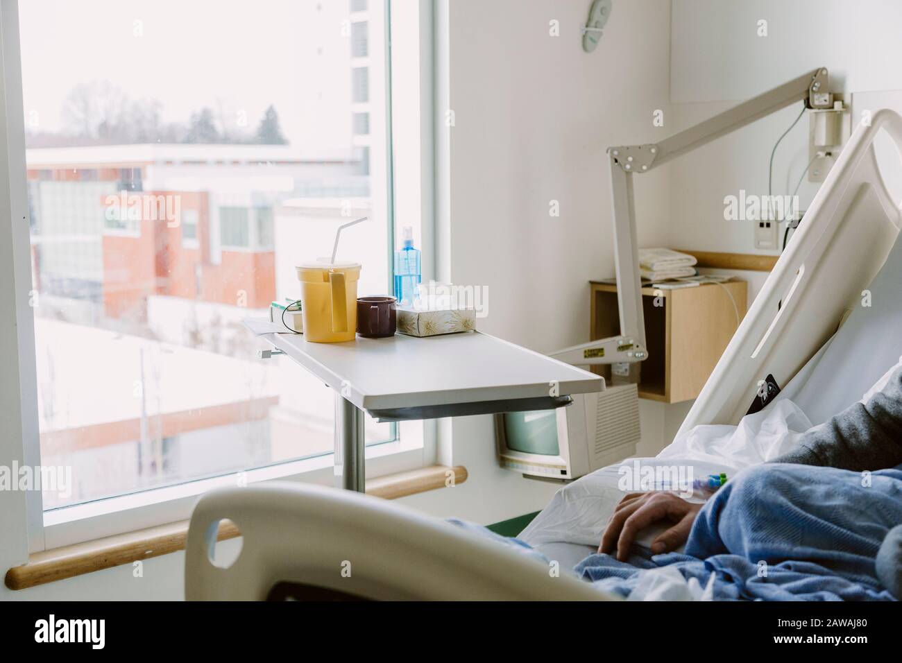 Hand of male sitting in hospital bed looking out the window Stock Photo ...
