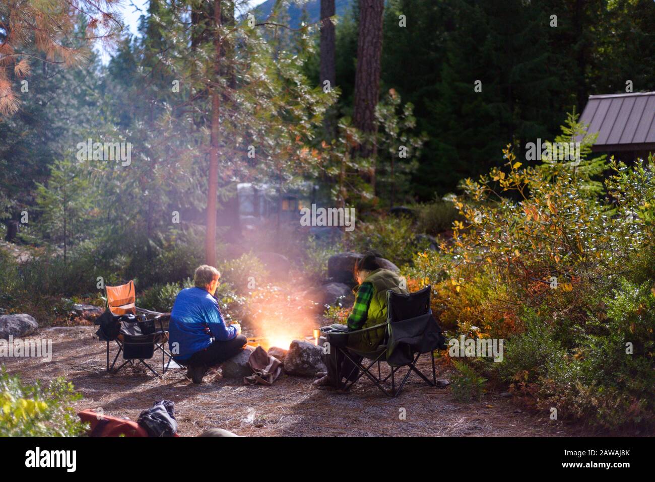 Sitting Around The Campfire In A Campground Stock Photo - Alamy