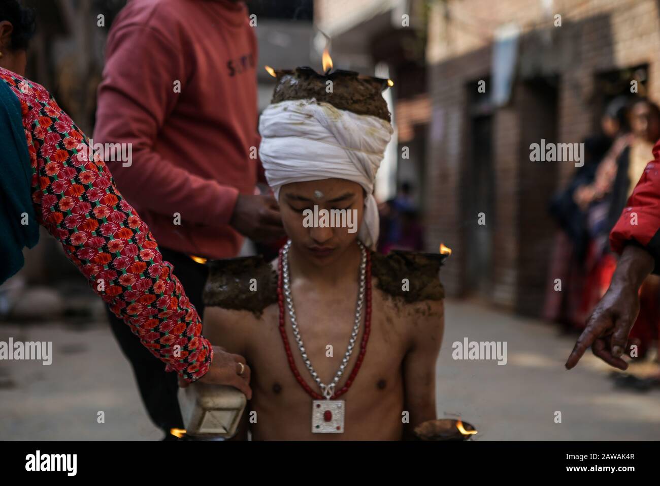 A devotee with lit oil lamps performing religious rituals during the ...