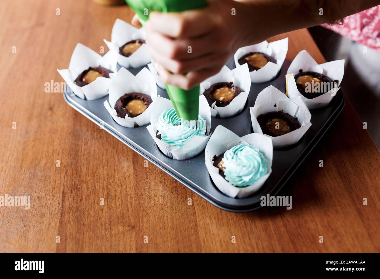 Decorating Homemade Chocolate Muffins With Blue Cream Topping Stock ...