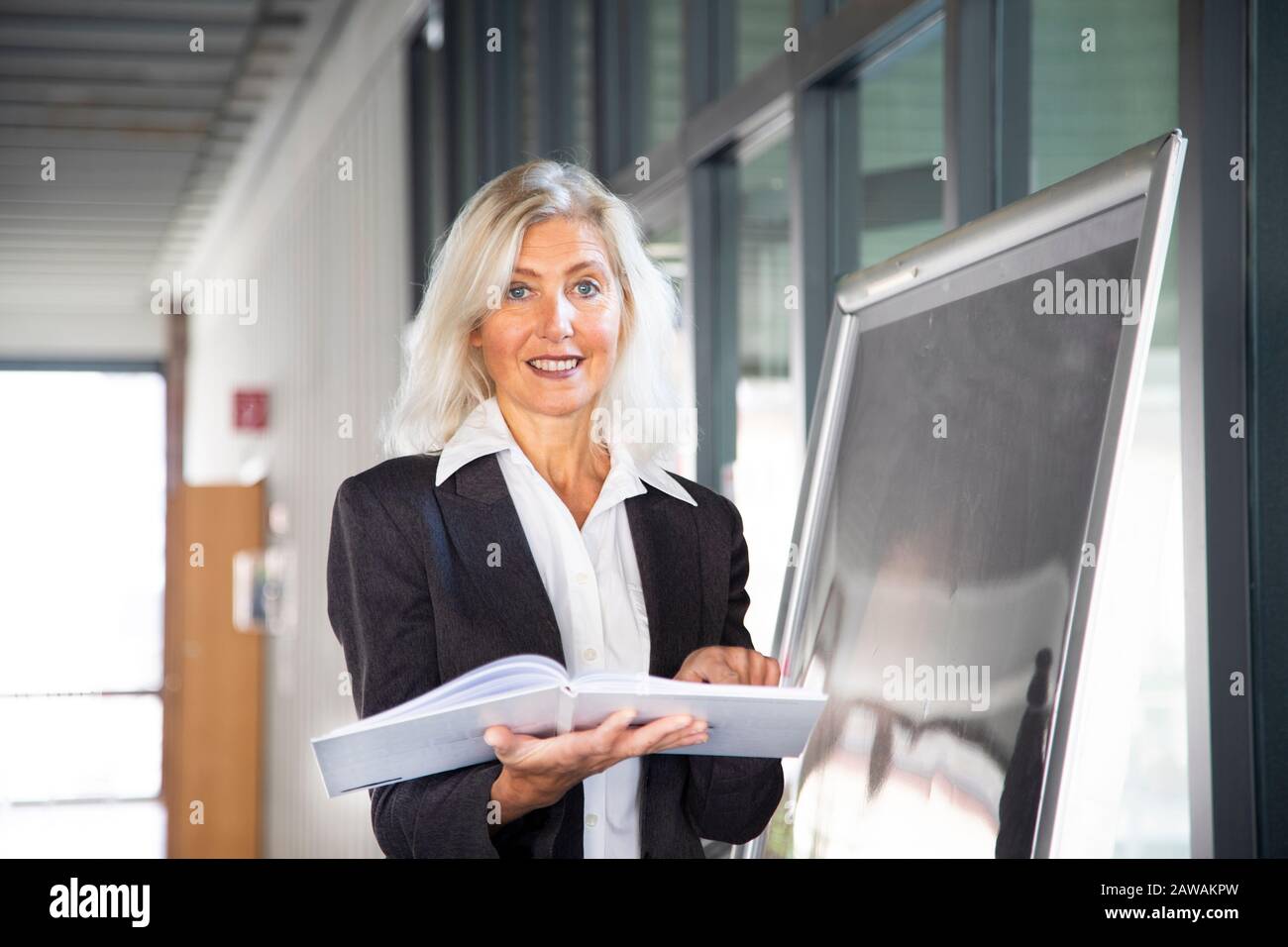 leader manager older woman standing with book near flipchart Stock ...