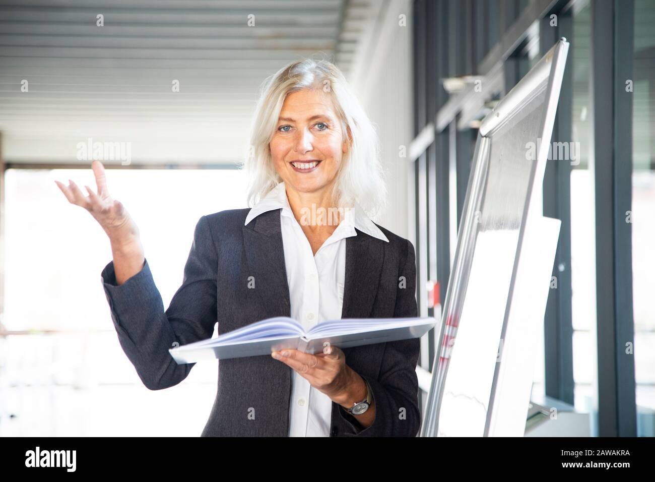 leader manager older woman standing with book near flipchart Stock ...