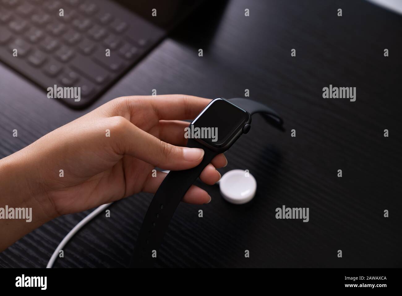 hand holding smart watch recharge in wireless charger Stock Photo - Alamy