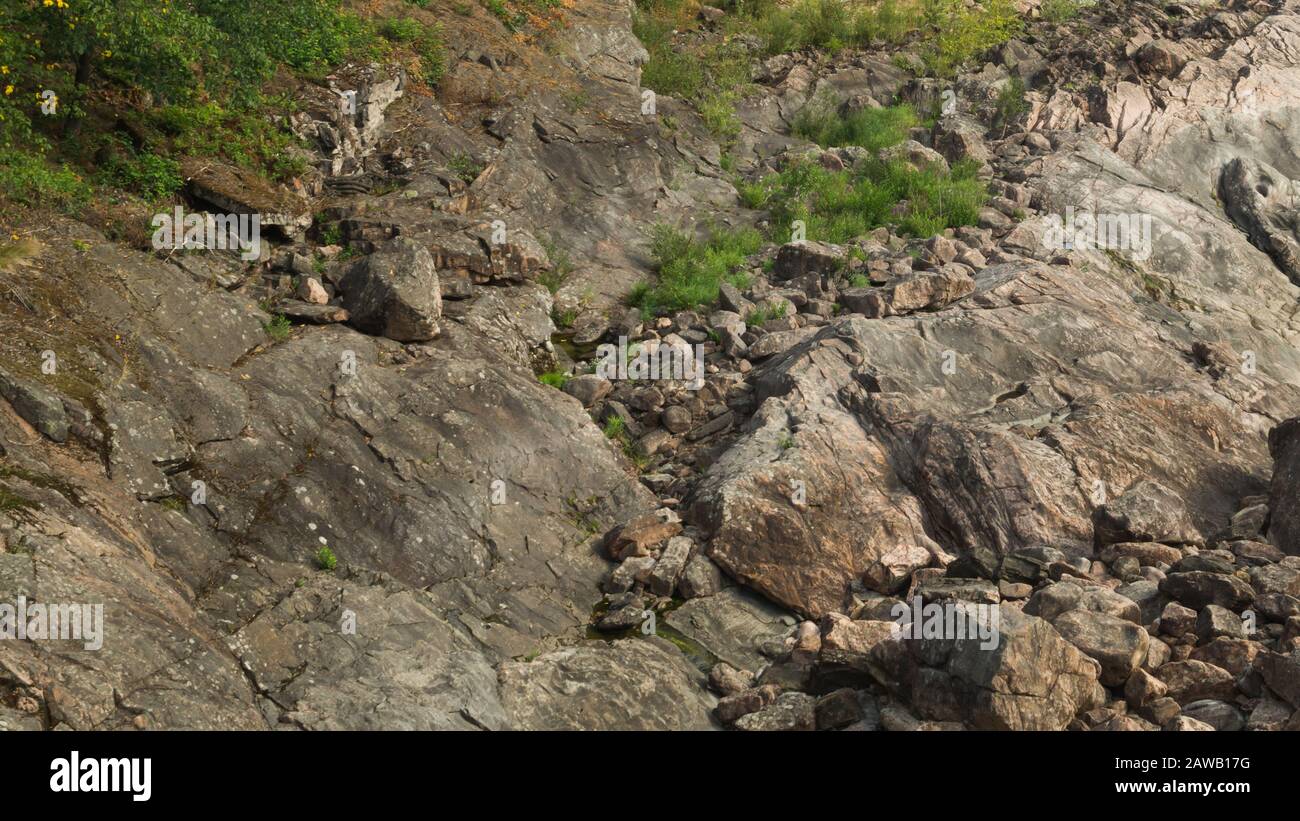 Rock of layered stone overgrown with grass and moss. texture of stone ...