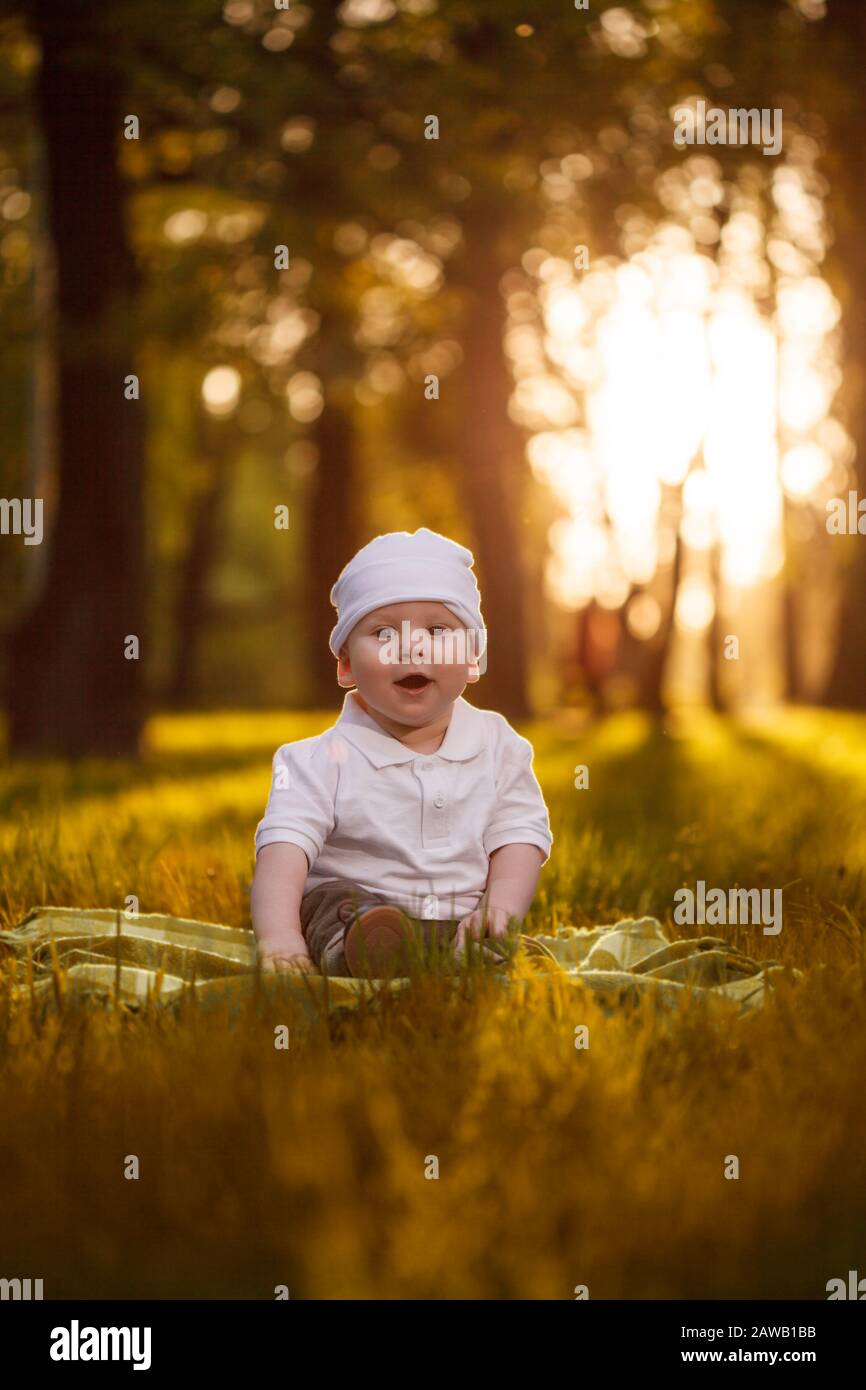 Baby in the park in the rays of sunset. Toddler on the nature outdoors ...