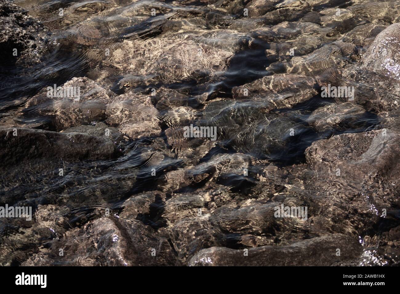 Shiny transparent water. clear water with pebbles and stone on the ...