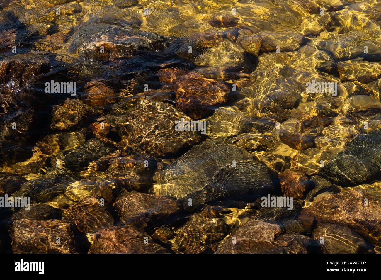 Shiny transparent water. clear water with pebbles and stone on the ...