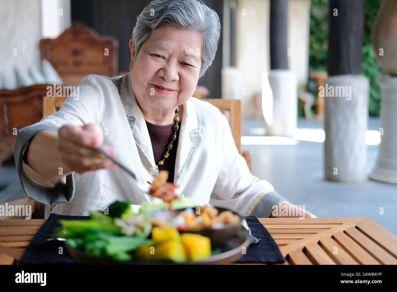 old elderly senior elder woman eating food at restaurant. mature ...