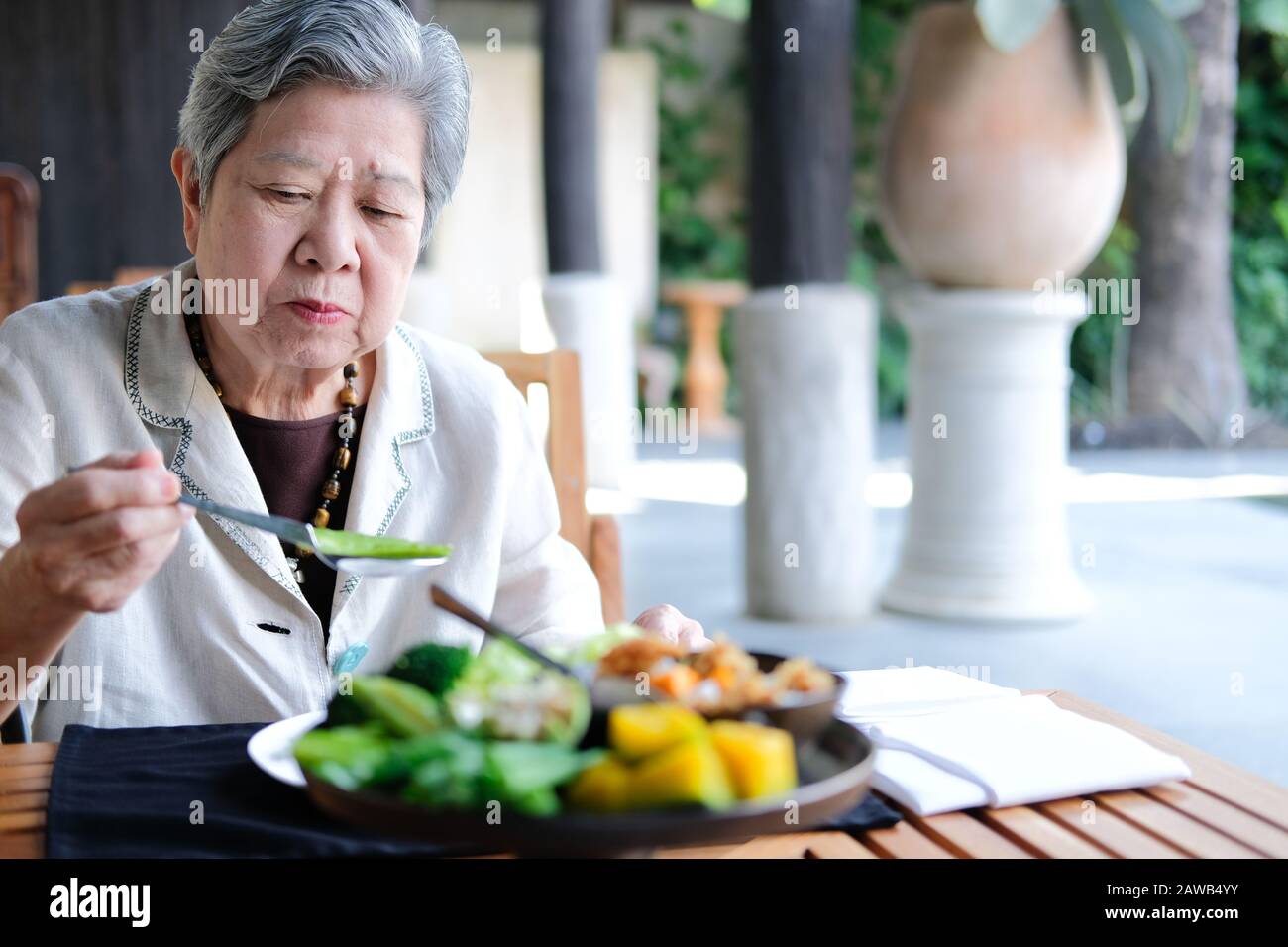 old elderly senior elder woman eating food at restaurant. mature ...