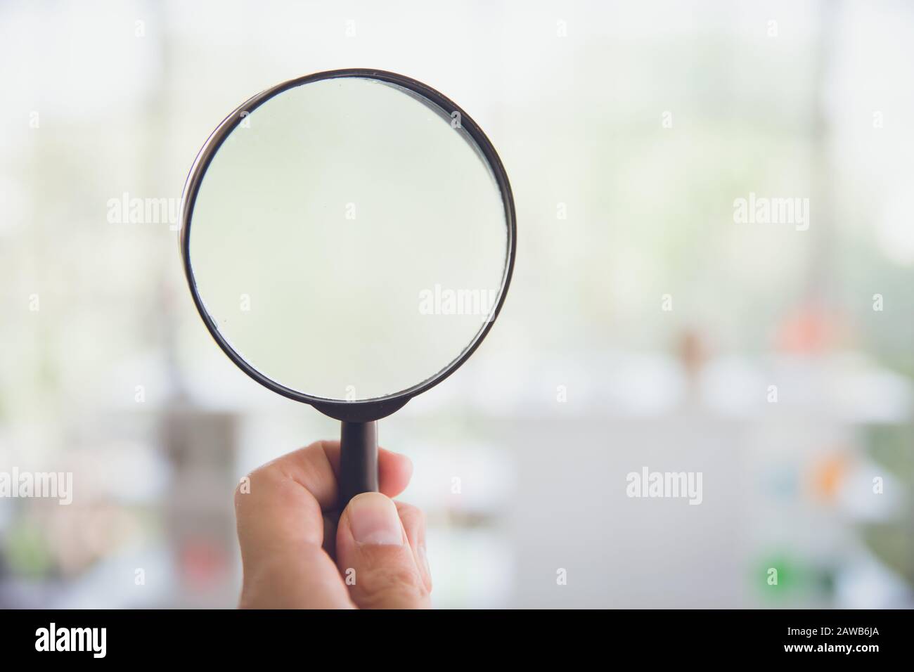Magnifying glass with blur indoor home background Stock Photo - Alamy
