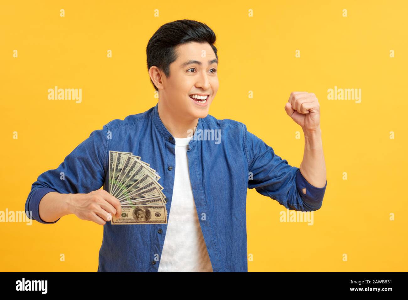 Successful Asian man. Happy young man holding money while standing and ...