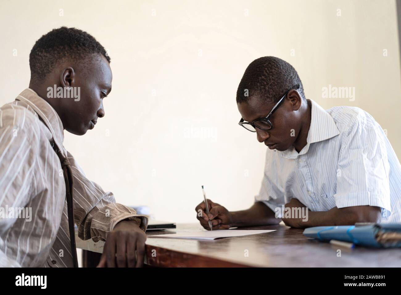 Two intelligent business men working together and signing documents and ...