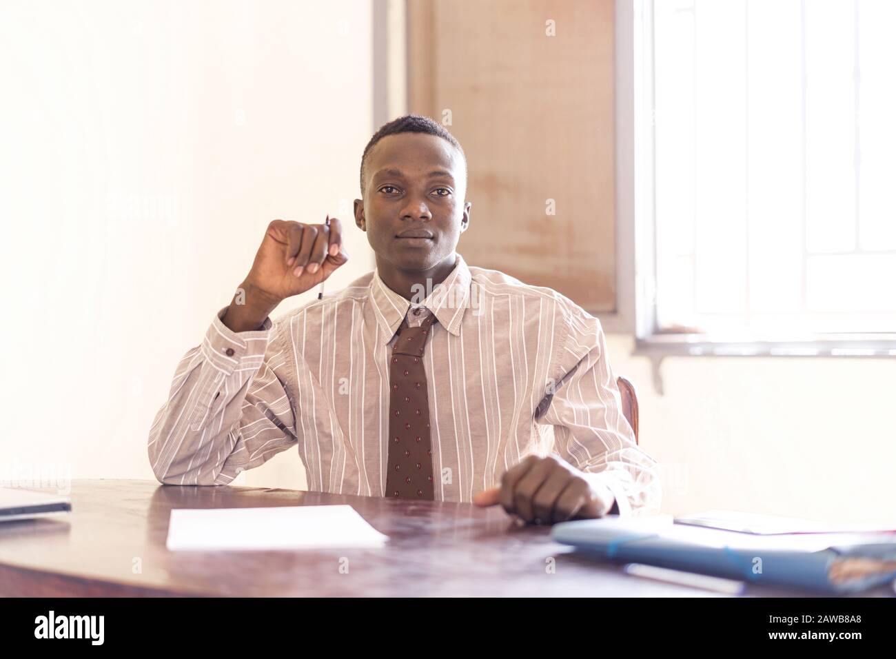 Sitting African Businessman working on documents on desk in front of ...