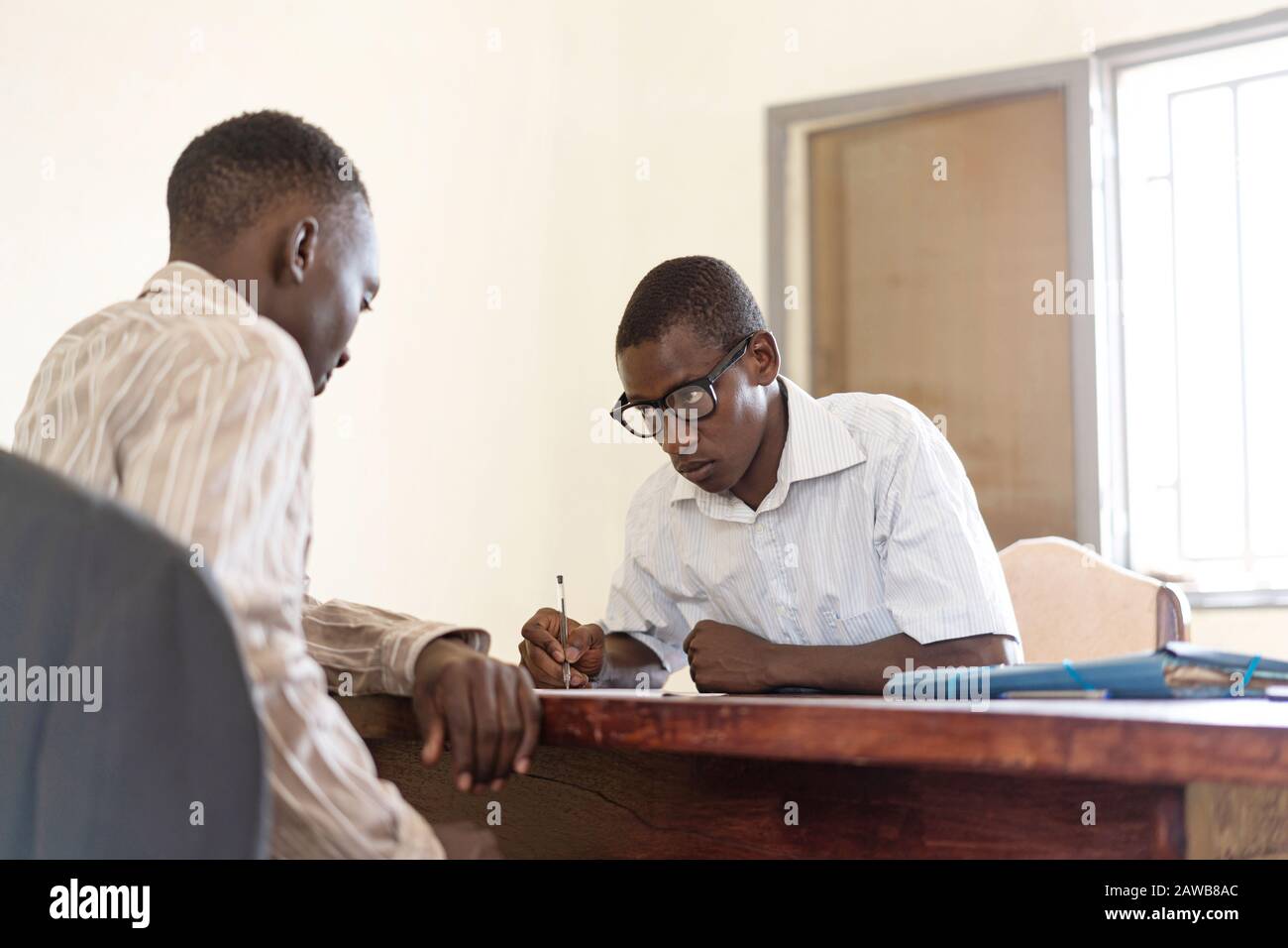 African employees working together in an office, signing papers and ...