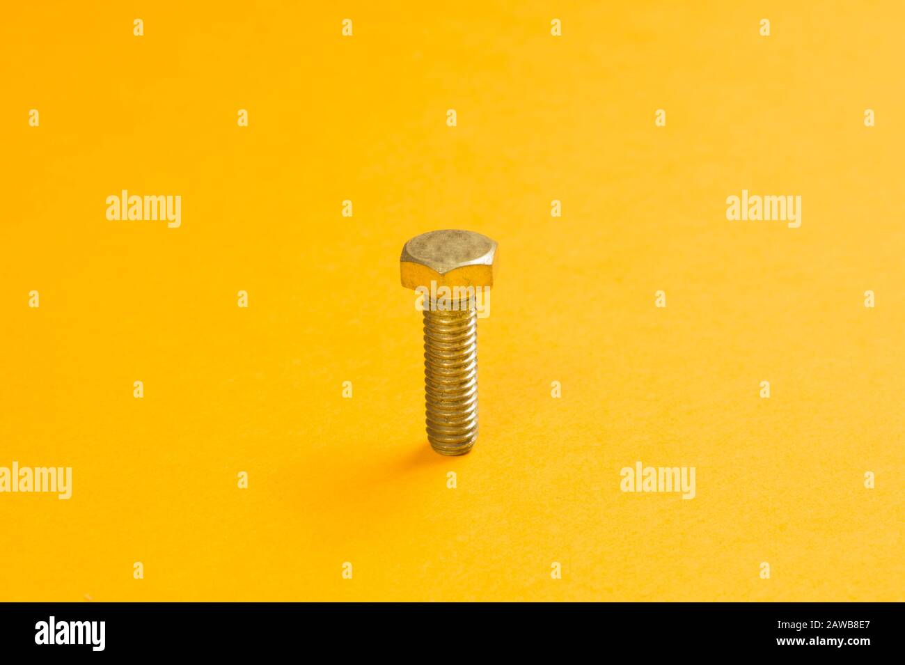Steel screw on a yellow background. working tools Stock Photo - Alamy