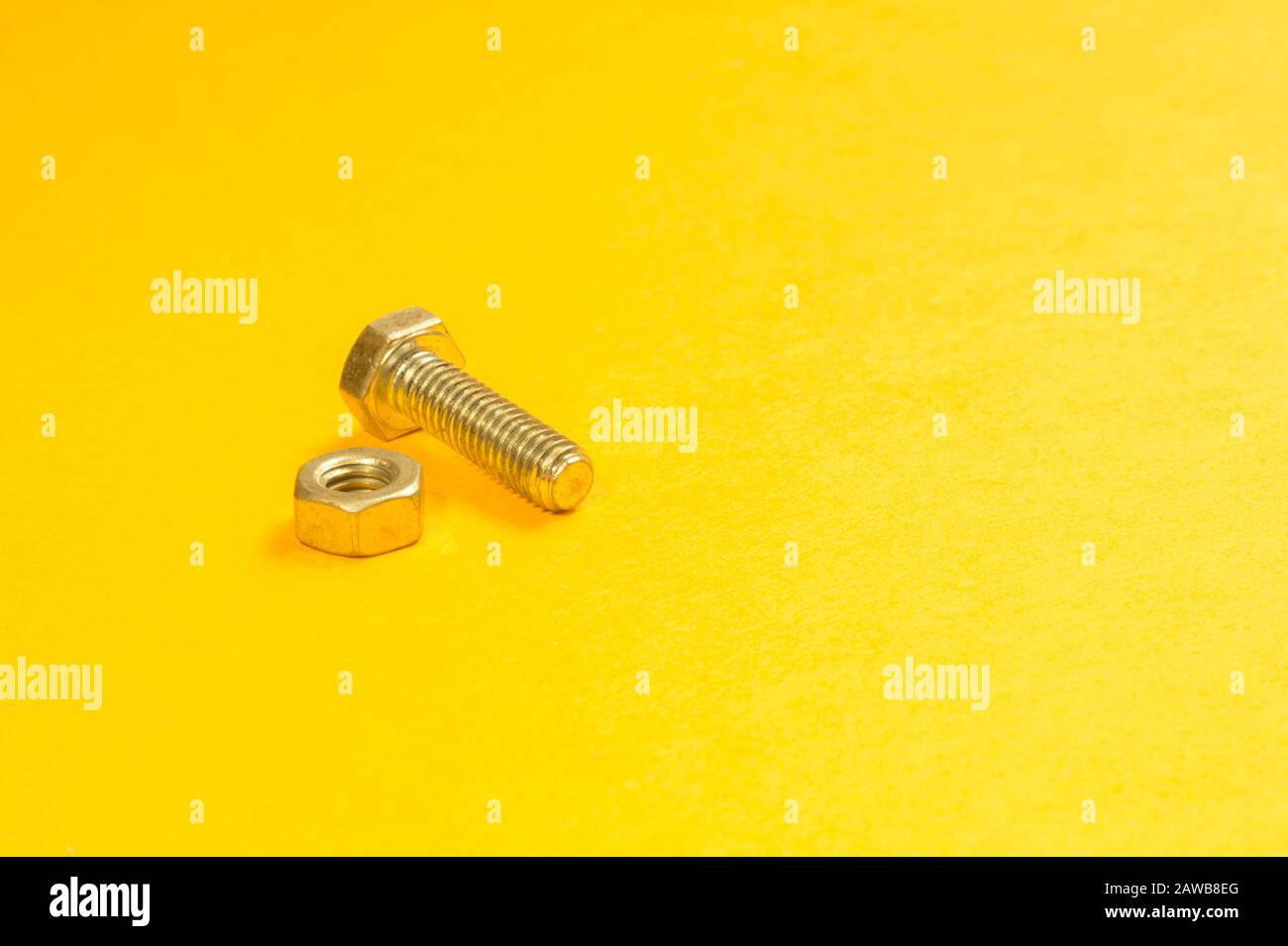 Steel screw on a yellow background. working tools Stock Photo - Alamy