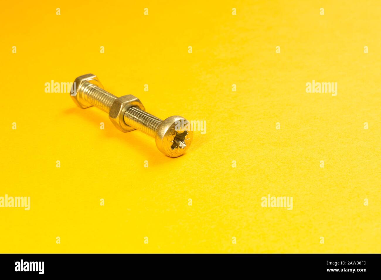 Steel screw on a yellow background. working tools Stock Photo - Alamy