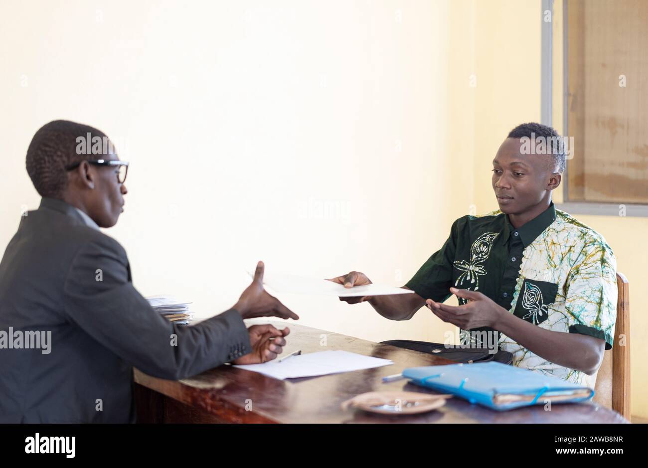 Candid photo of African black job application form being handed over to ...
