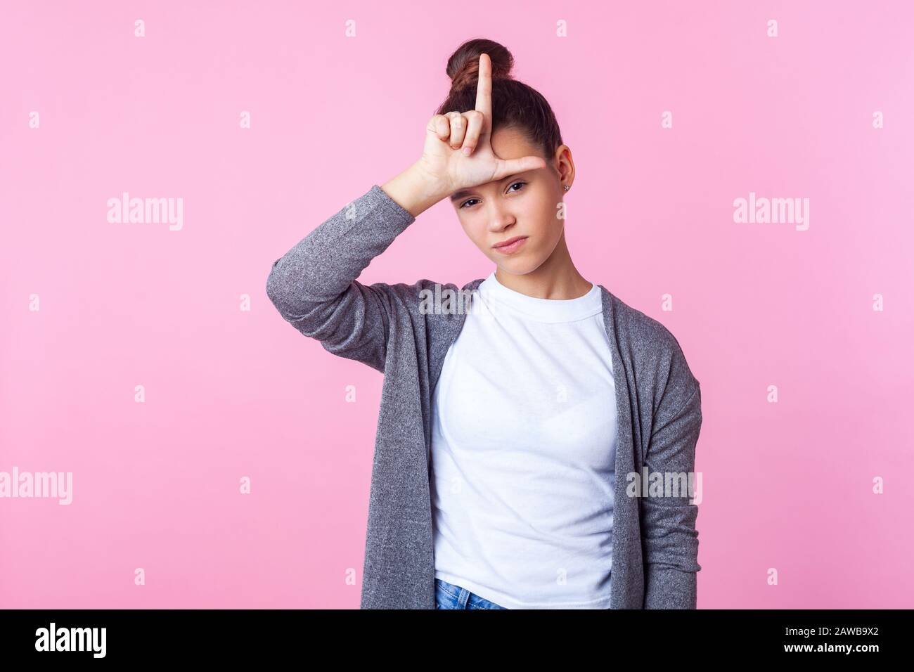 I'm loser. Portrait of brunette teen girl with bun hairstyle in casual ...