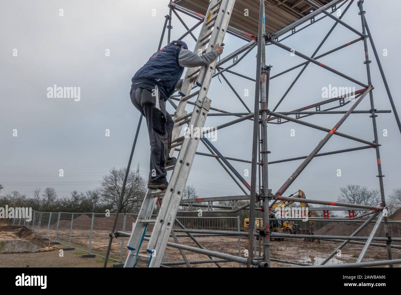 a man climbs onto scaffolding on an extension ladder Stock Photo - Alamy