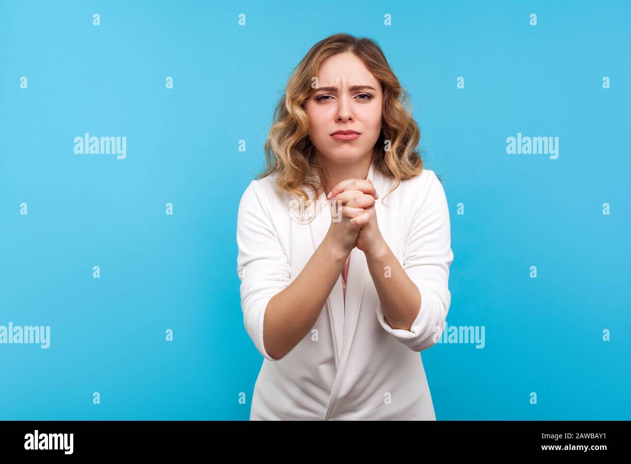 Please, I'm begging! Portrait of pleading woman with wavy hair in white ...