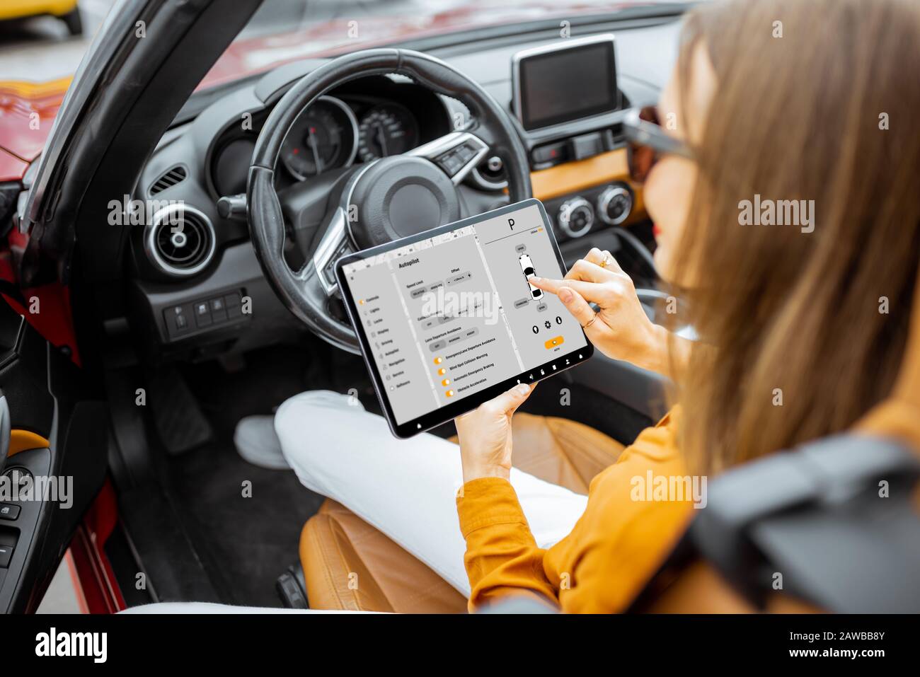 Young woman controlling car using a digital tablet and mobile ...