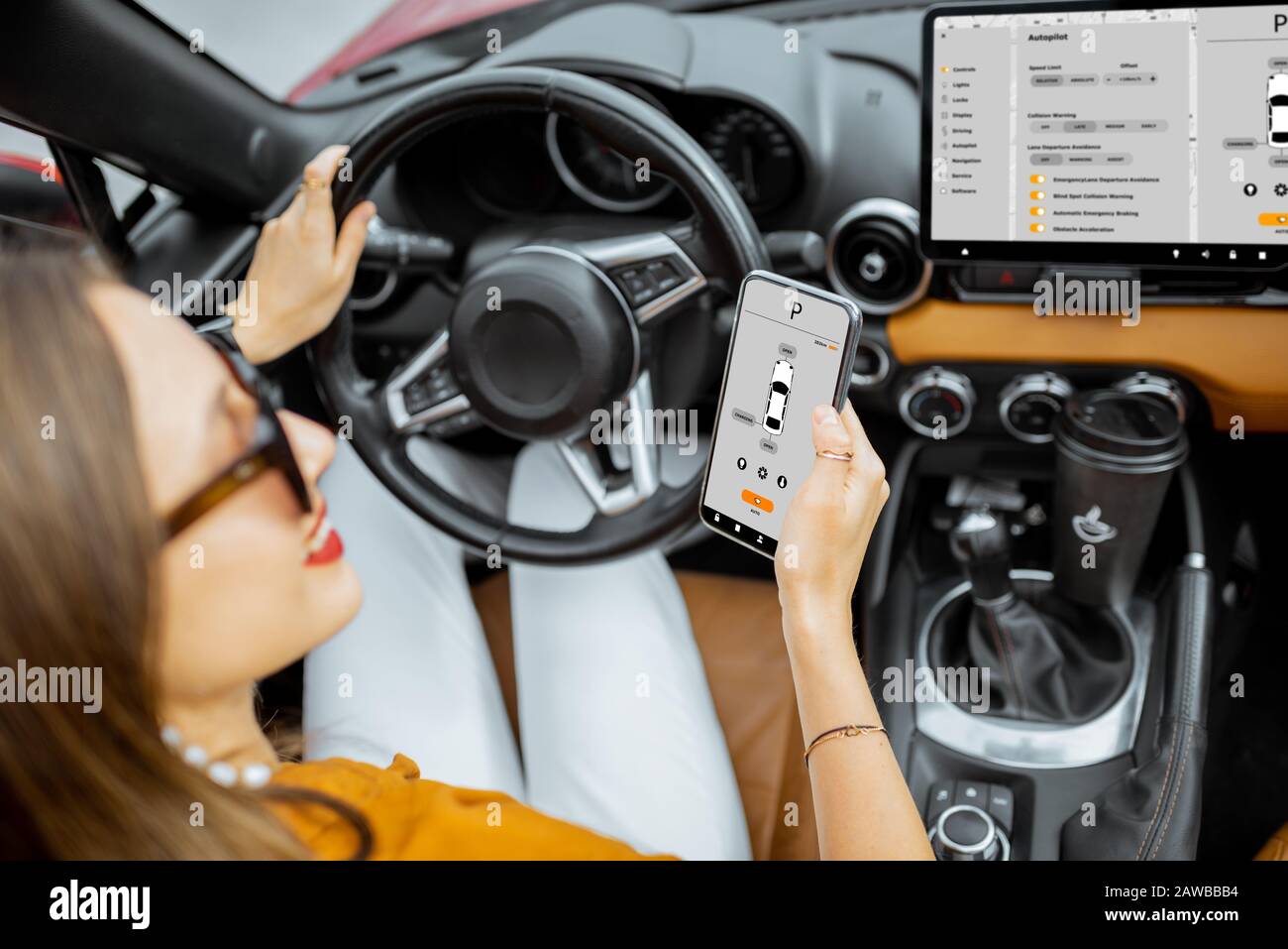 Young woman controlling car using smart phone with launched mobile ...
