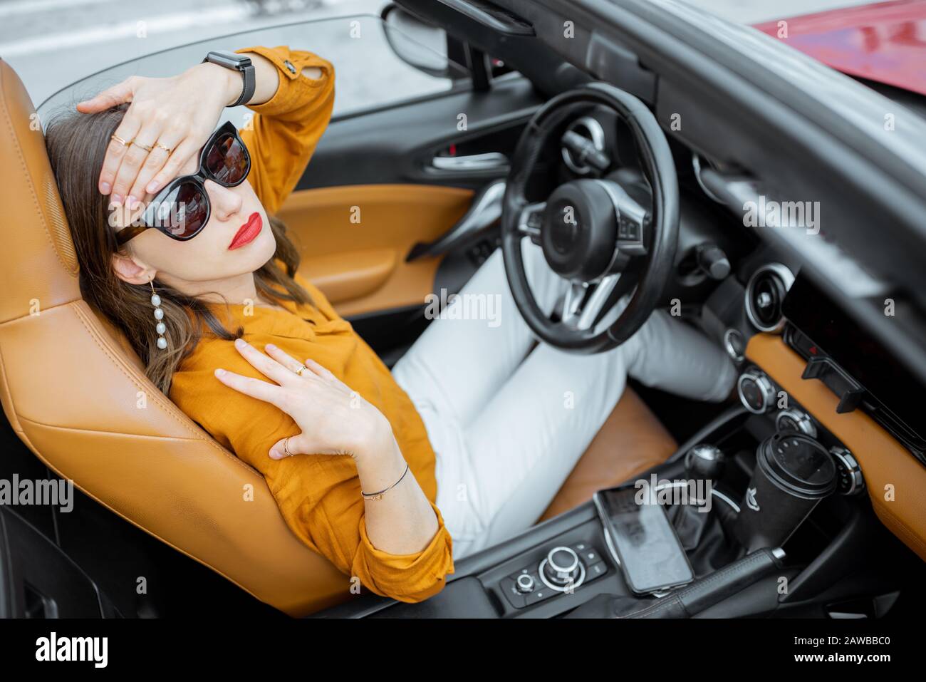 Young woman feeling headache while sitting on the driver's seat of ...