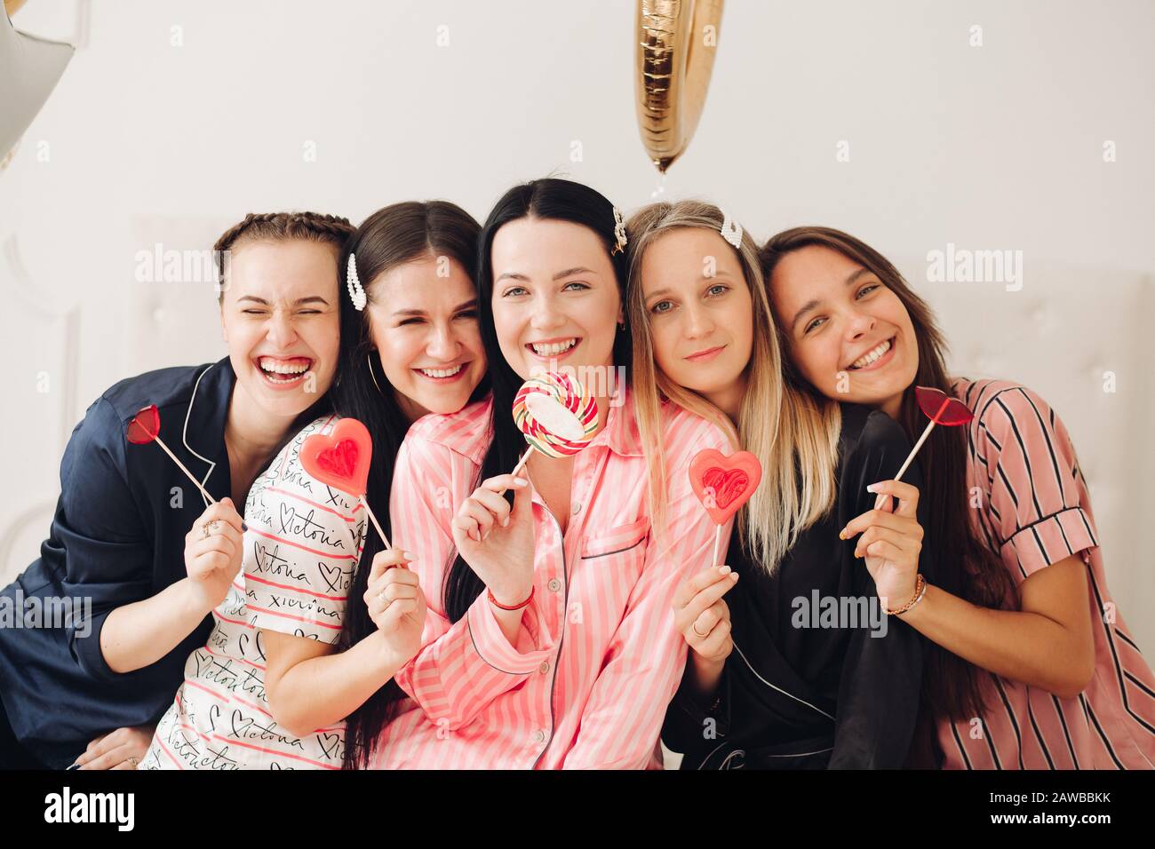 Pretty girlfriends with lollipops in front of lips Stock Photo - Alamy