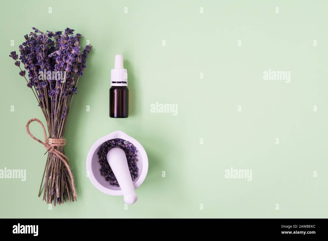 Spa background with violet flowers and glass vial with essential oil ...