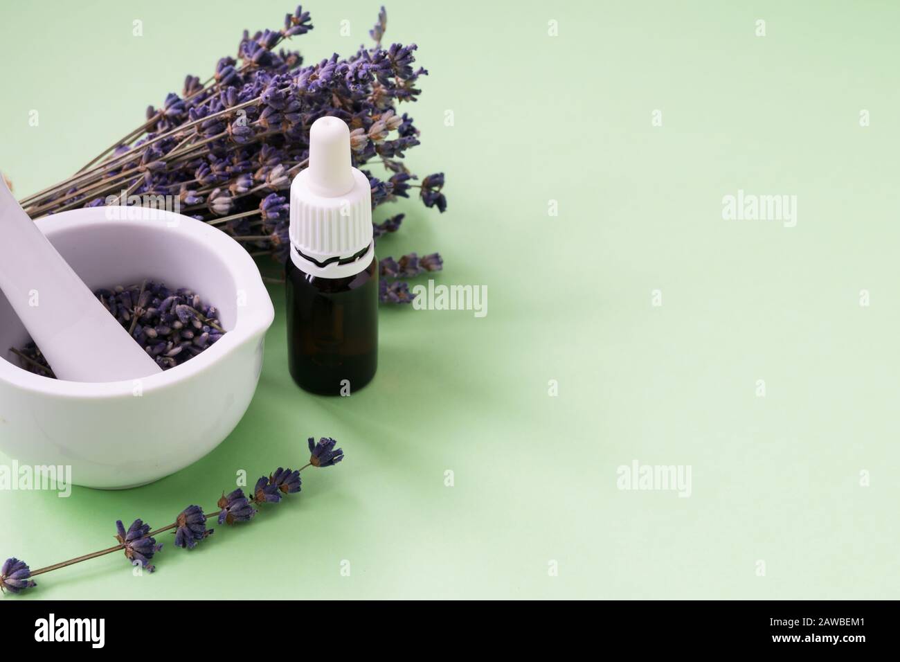 Spa background with violet flowers and glass vial with essential oil ...