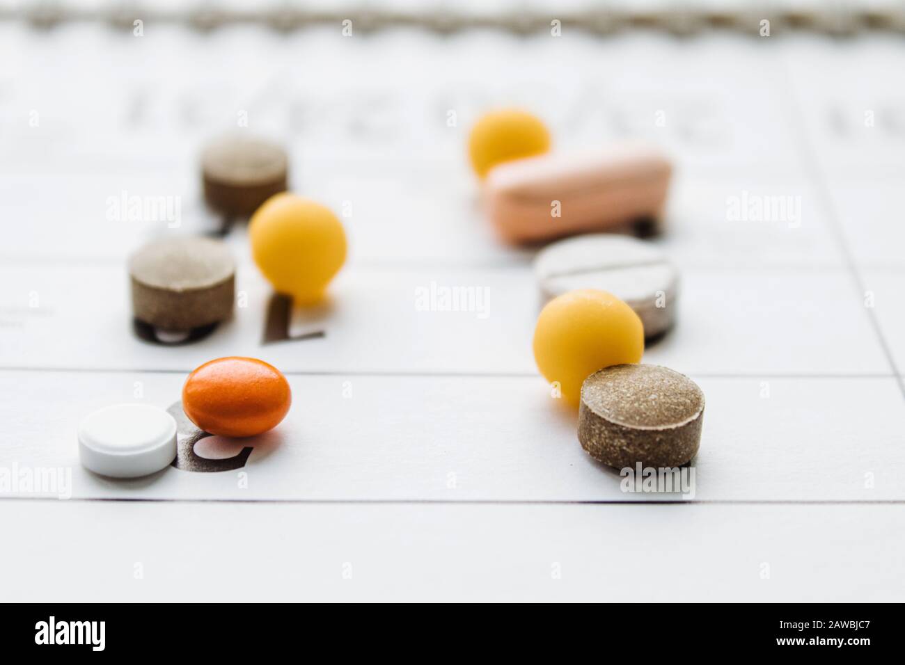 A bunch of different pills on a calendar background. Pills, supplements ...