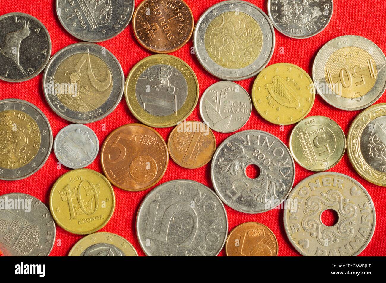 Coins of the different countries on the red background. many metal ...