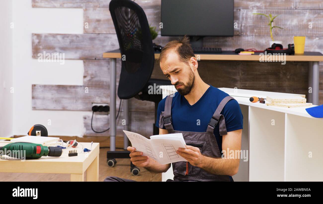 Concentrated worker reading assembly instruction for furniture ...