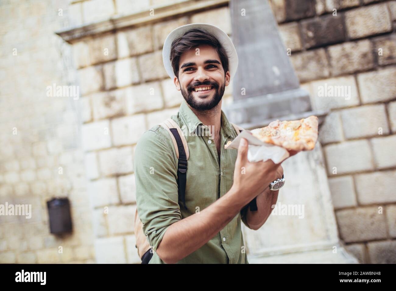 Happy man eating pizza on street Stock Photo - Alamy
