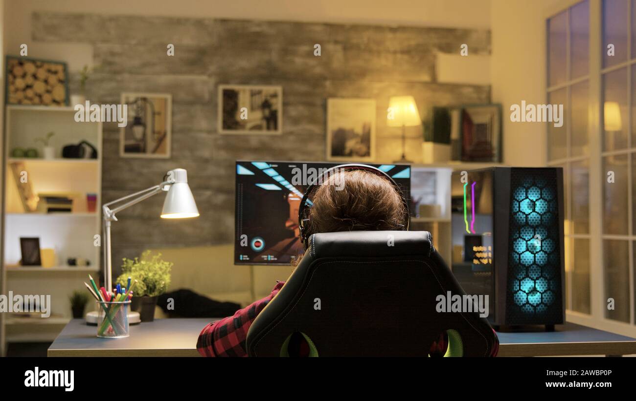 Female gamer celebrating victory with hands raised on computer games ...