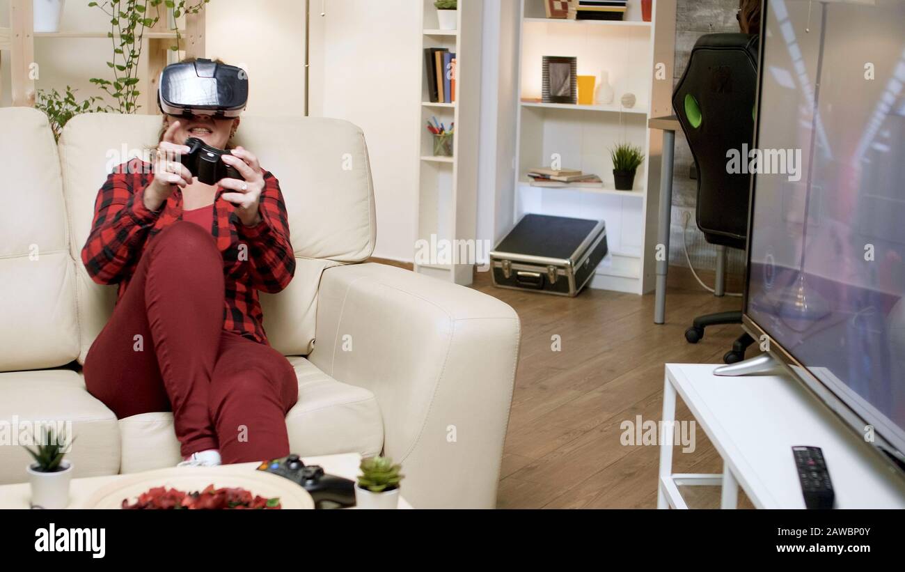 Young woman wearing vr headset while playing video games. Boyfriend ...