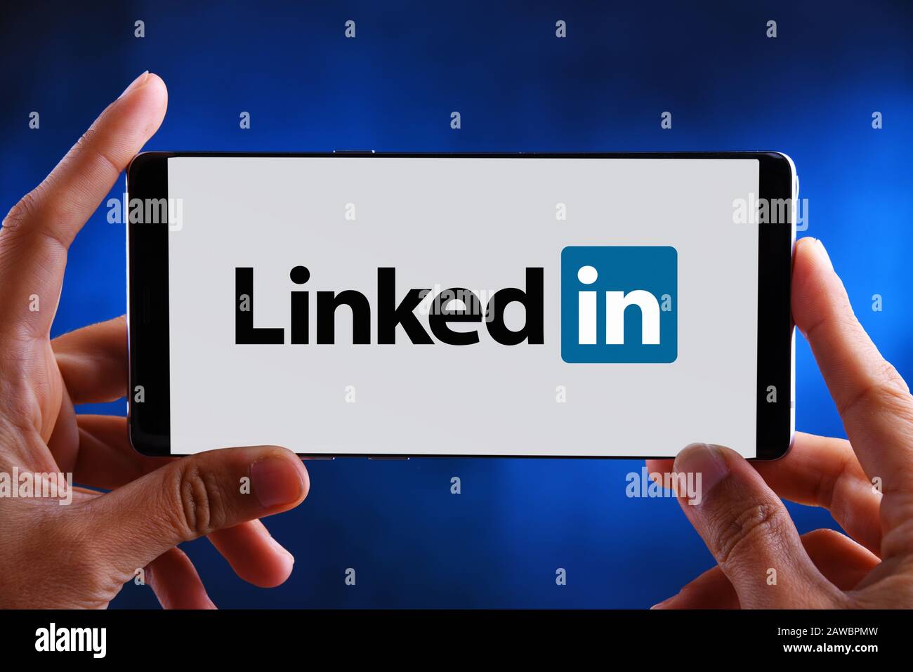 POZNAN, POL - JUL 10, 2019: Hands holding smartphone displaying logo of ...