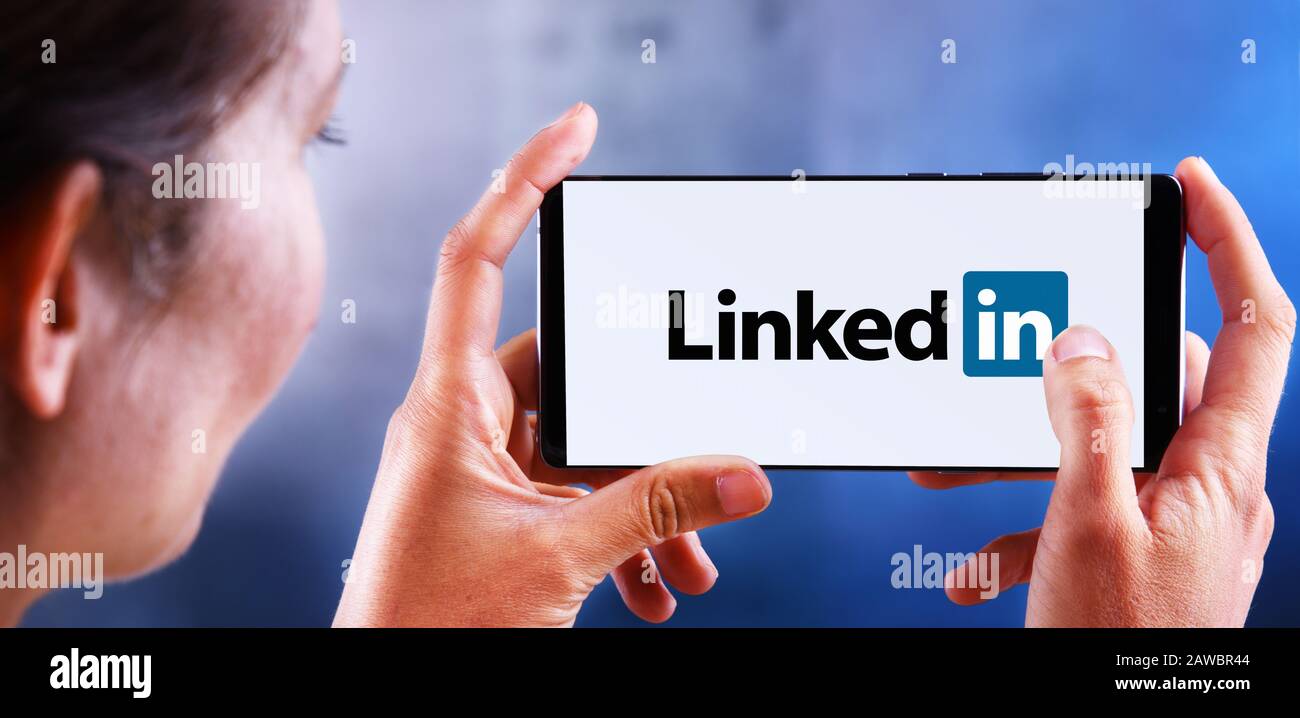 POZNAN, POL - JUL 10, 2019: Woman holding smartphone displaying logo of ...