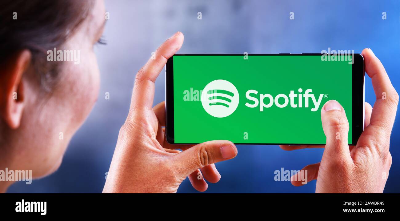 POZNAN, POL - JUL 10, 2019: Woman holding smartphone displaying logo of ...