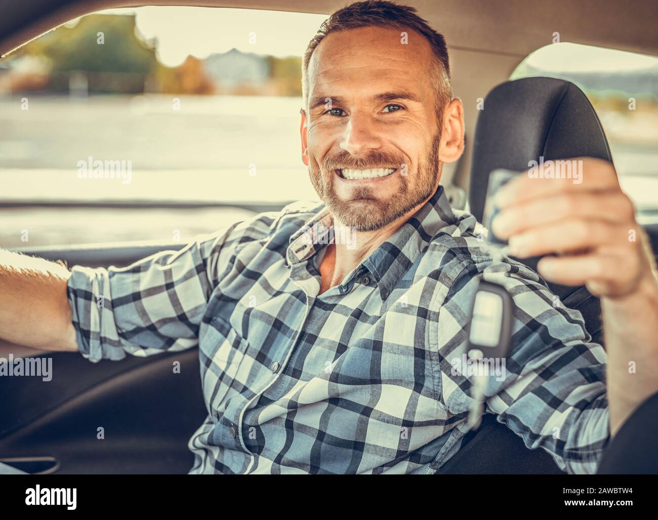 A man in a car shows a key Stock Photo - Alamy