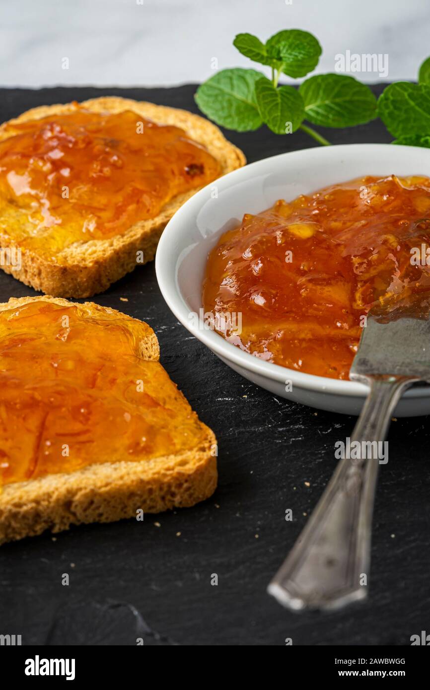 Dry toast with orange marmalade. Close-up Stock Photo - Alamy