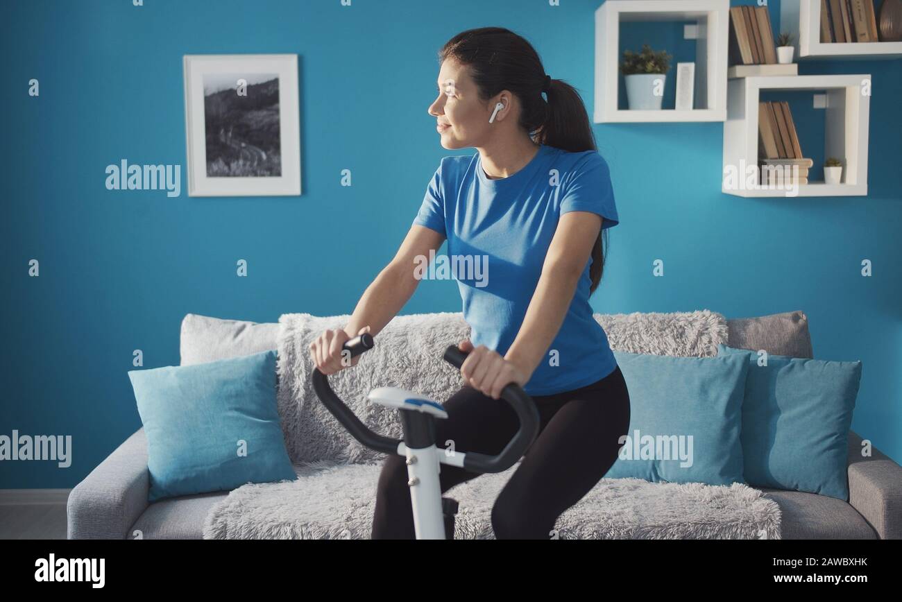 Sporty girl on exercise bike Stock Photo - Alamy