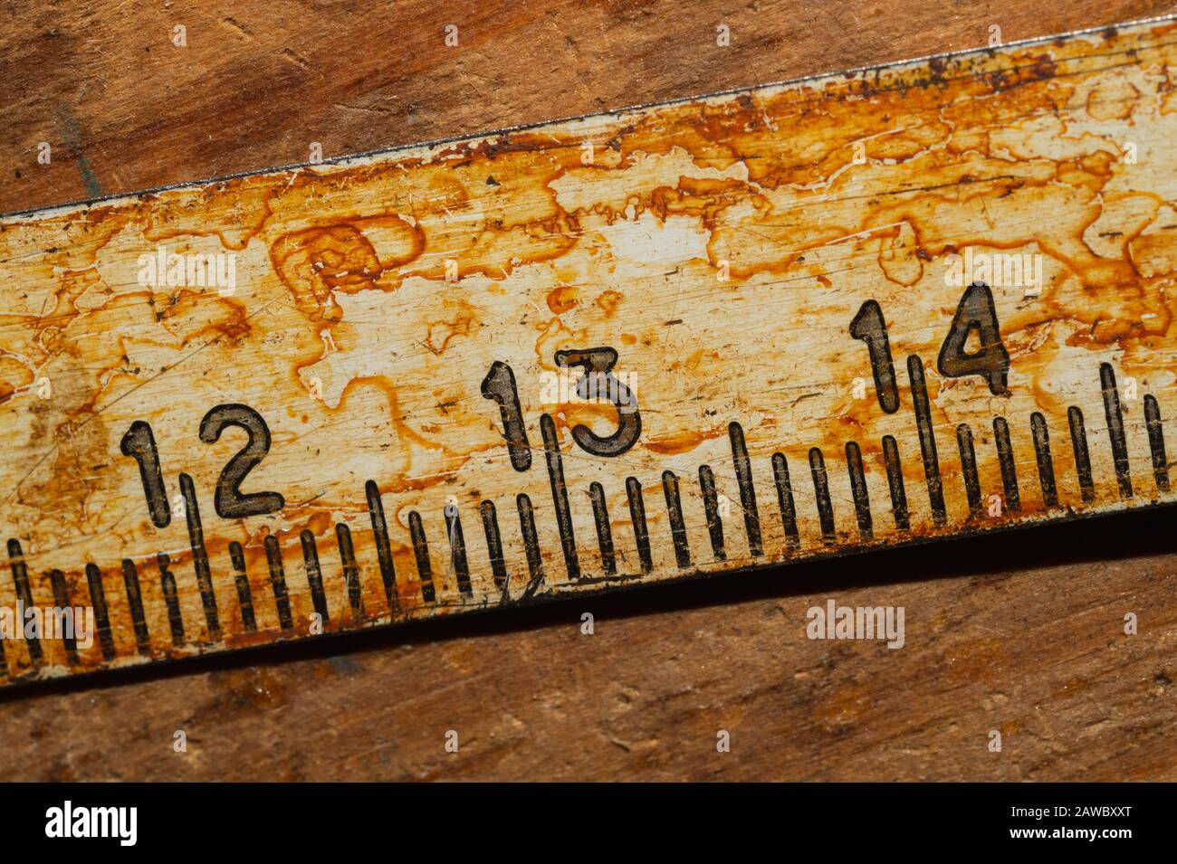 Old rusty ruler with black numbers on a working wooden table. vintage ...