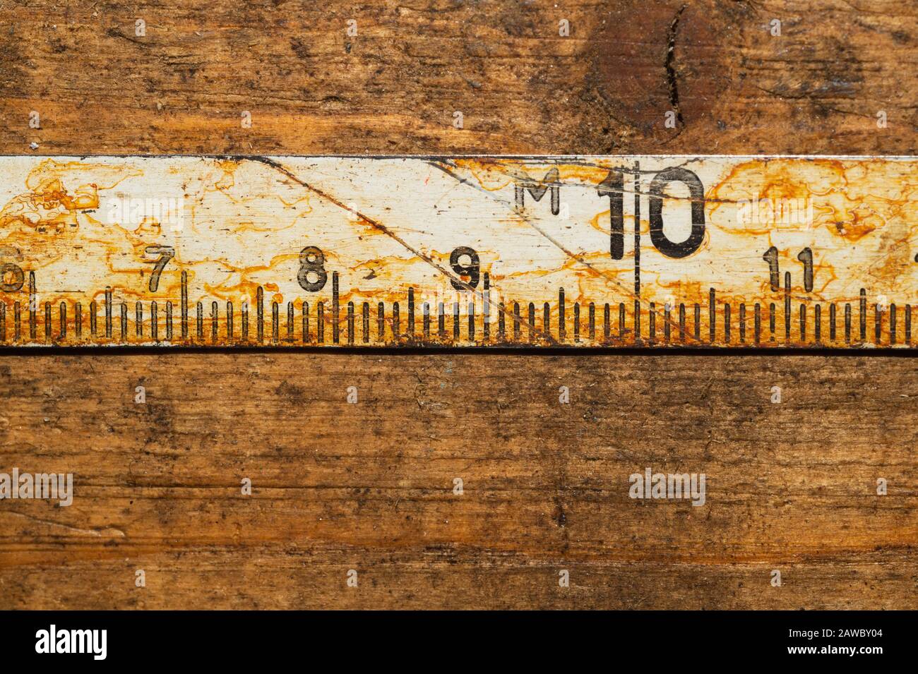 Old rusty ruler with black numbers on a working wooden table. vintage ...