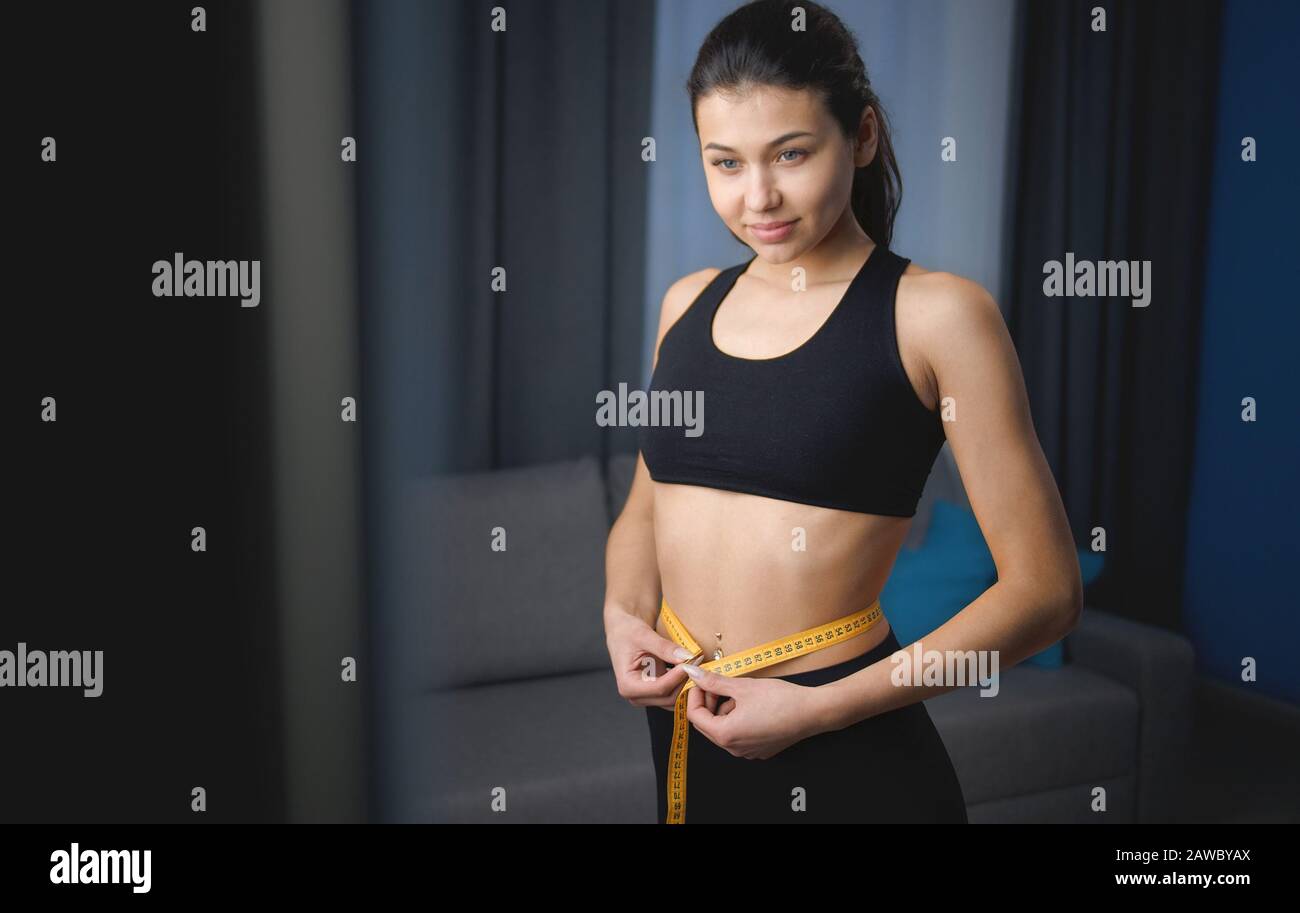 Slim female measuring her waist Stock Photo - Alamy
