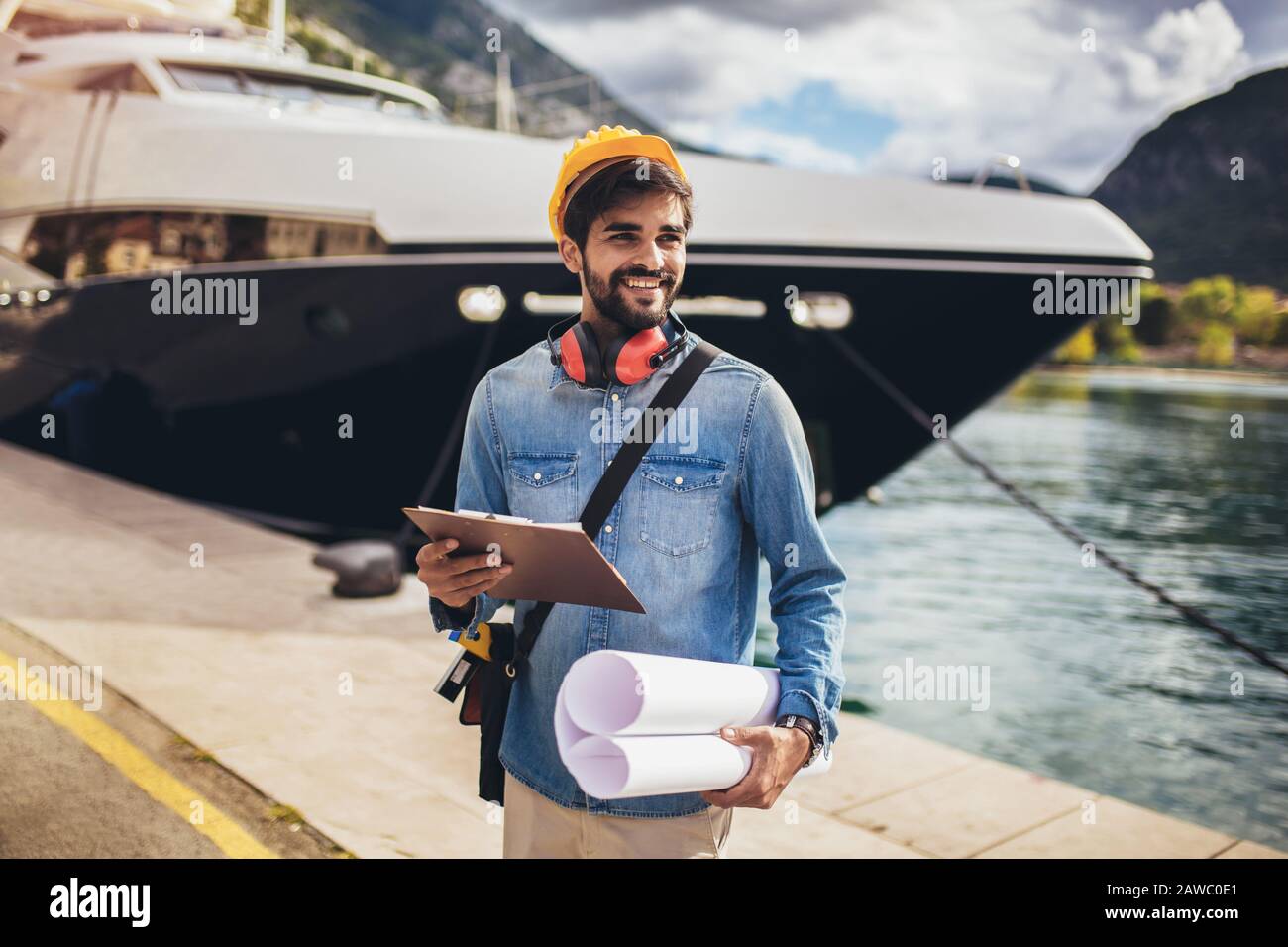 Harbor engineer holding the paper, construction work, smiling Stock ...