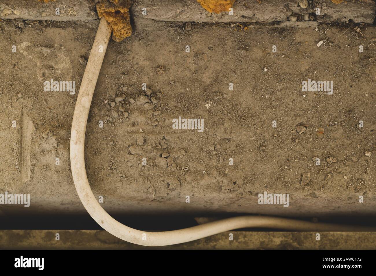 White cable sticking out of the wall. cabling process. industrial grey ...