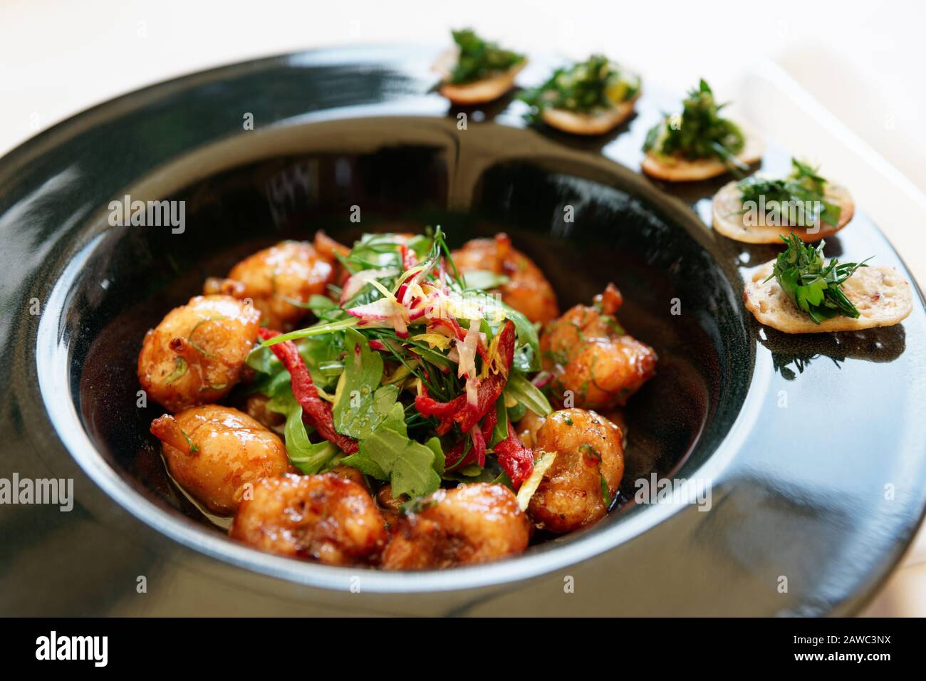 Fried frog legs in black plate on restaurant table, French dish Stock ...